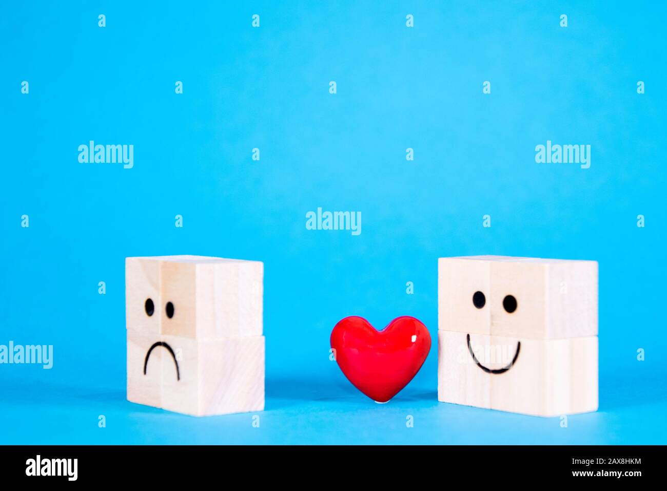 Wooden blocks with a happy face and a sad face, one giving a bright red ...