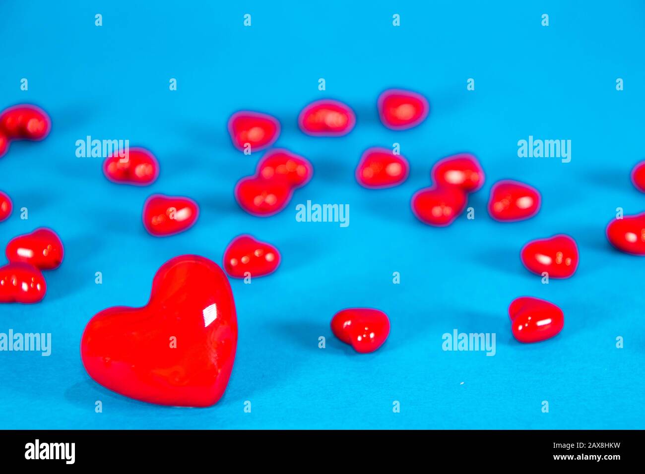 A scattering of love hearts, taken on a bright blue background, with ...
