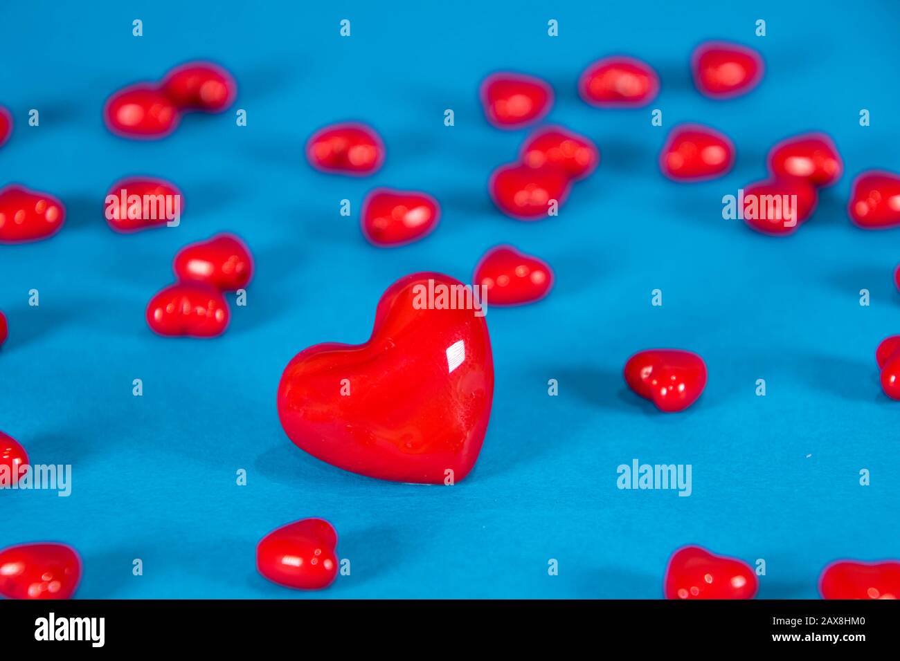 A scattering of love hearts, taken on a bright blue background, with ...