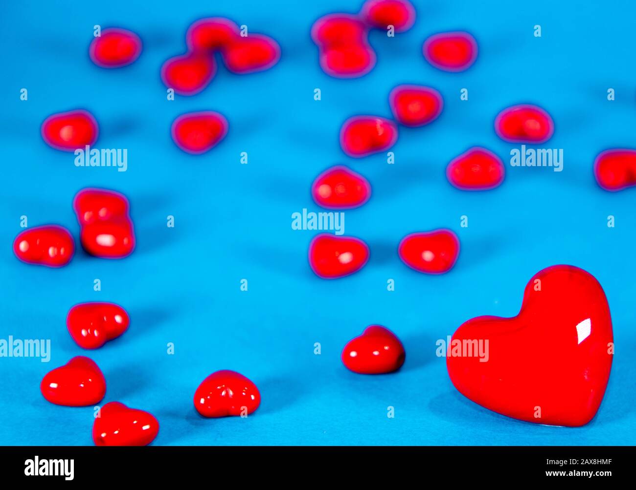 A scattering of love hearts, taken on a bright blue background, with ...