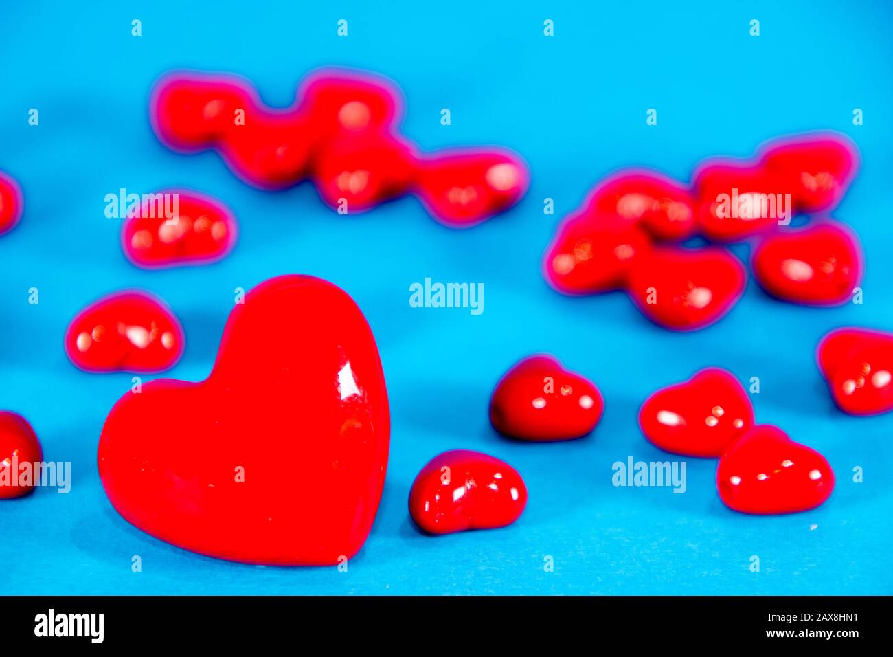 A scattering of love hearts, taken on a bright blue background, with ...