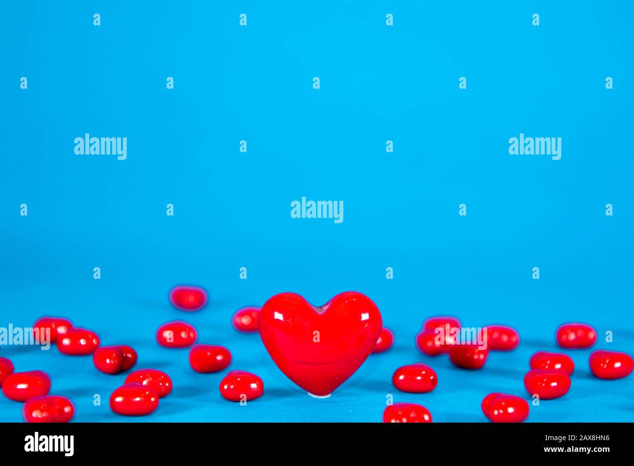 A scattering of love hearts, taken on a bright blue background, with ...