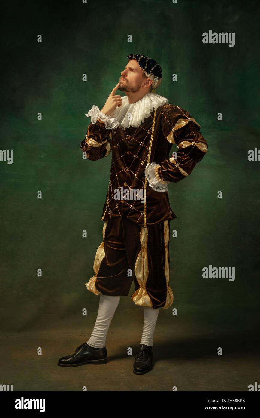 Posing thoughtful. Portrait of medieval young man in vintage clothing ...