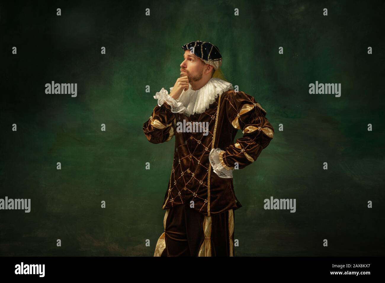 Posing thoughtful. Portrait of medieval young man in vintage clothing ...