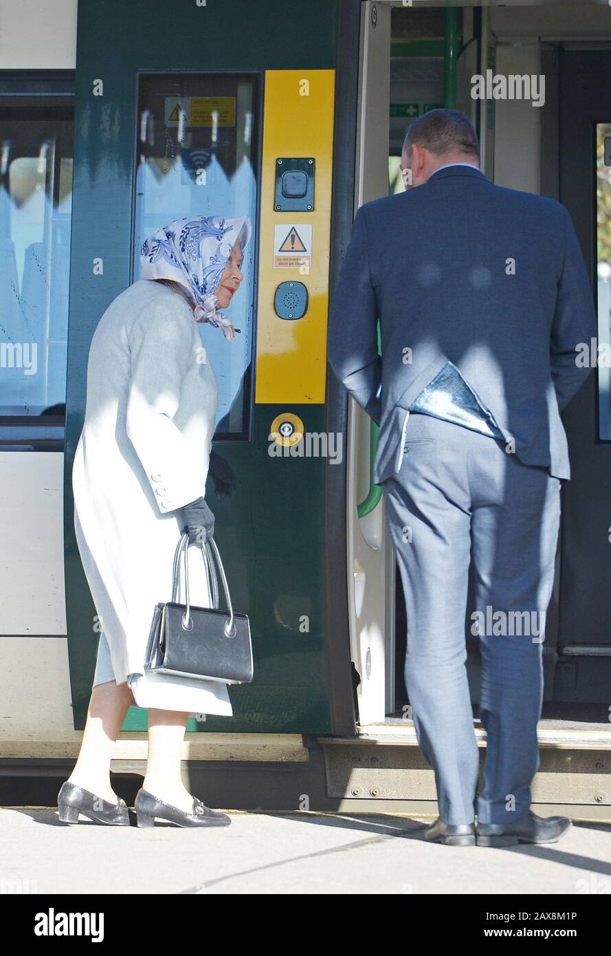 Queen Elizabeth II looks up at station manager Graeme Pratt whilst ...