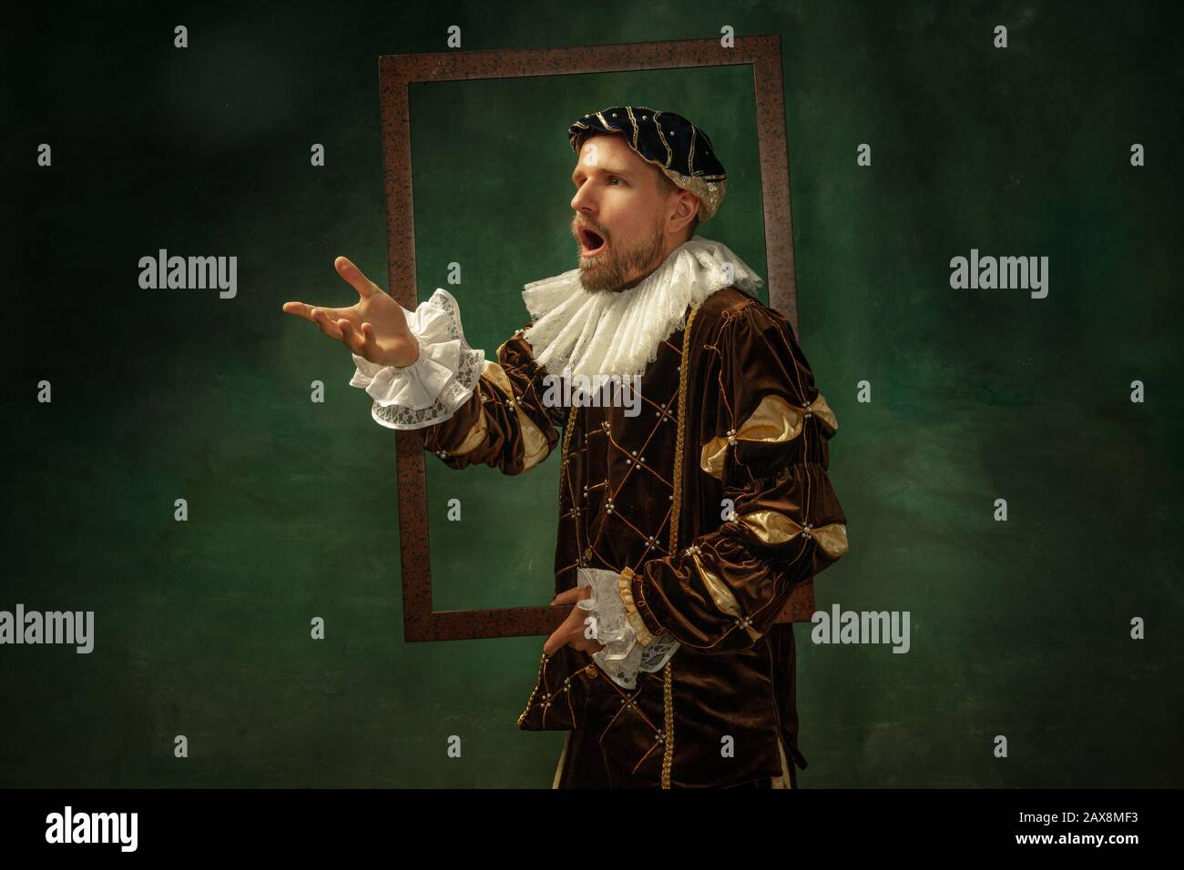 Shocked. Portrait of medieval young man in vintage clothing with wooden ...