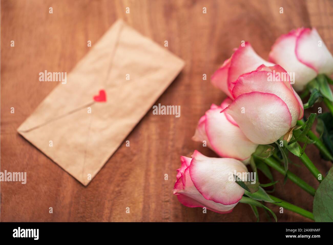 Valentine's day love letter & pink rose bouquet on wooden desk with ...