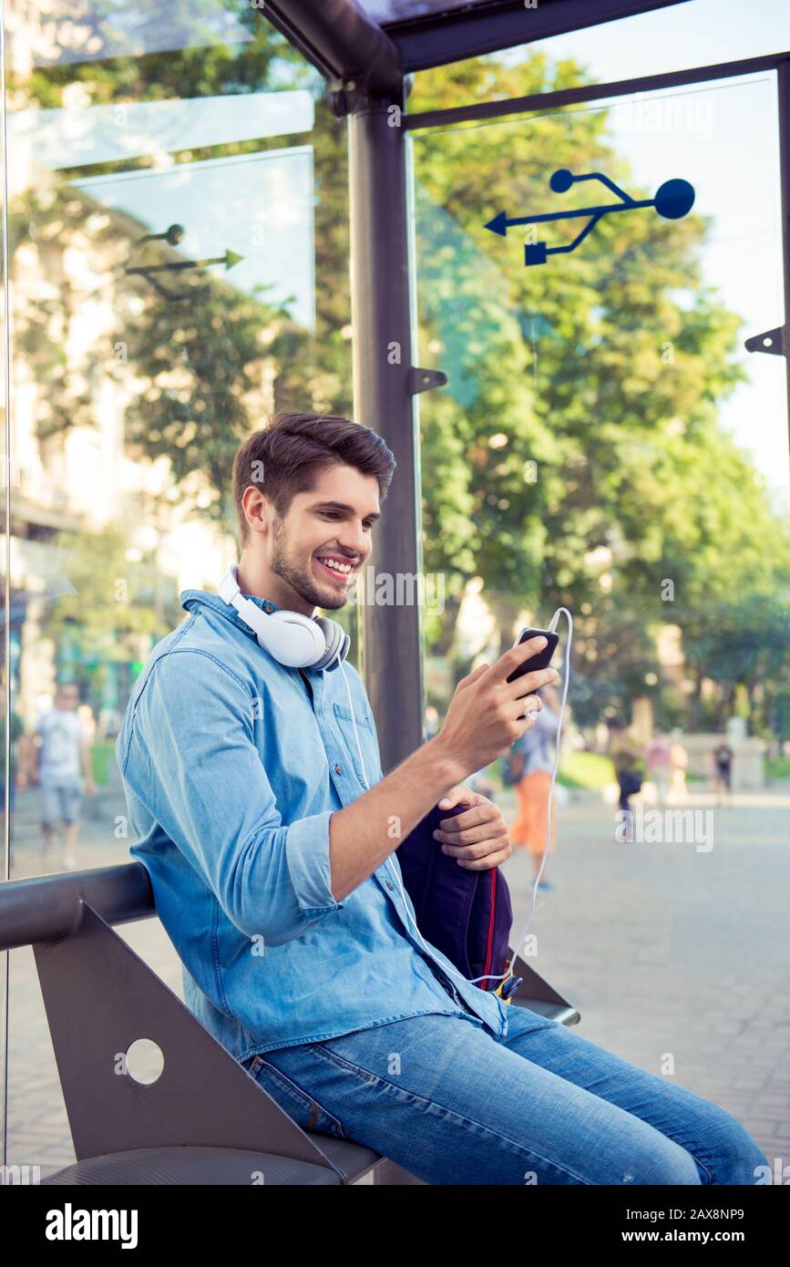Young man sitting bus stop hi-res stock photography and images - Alamy