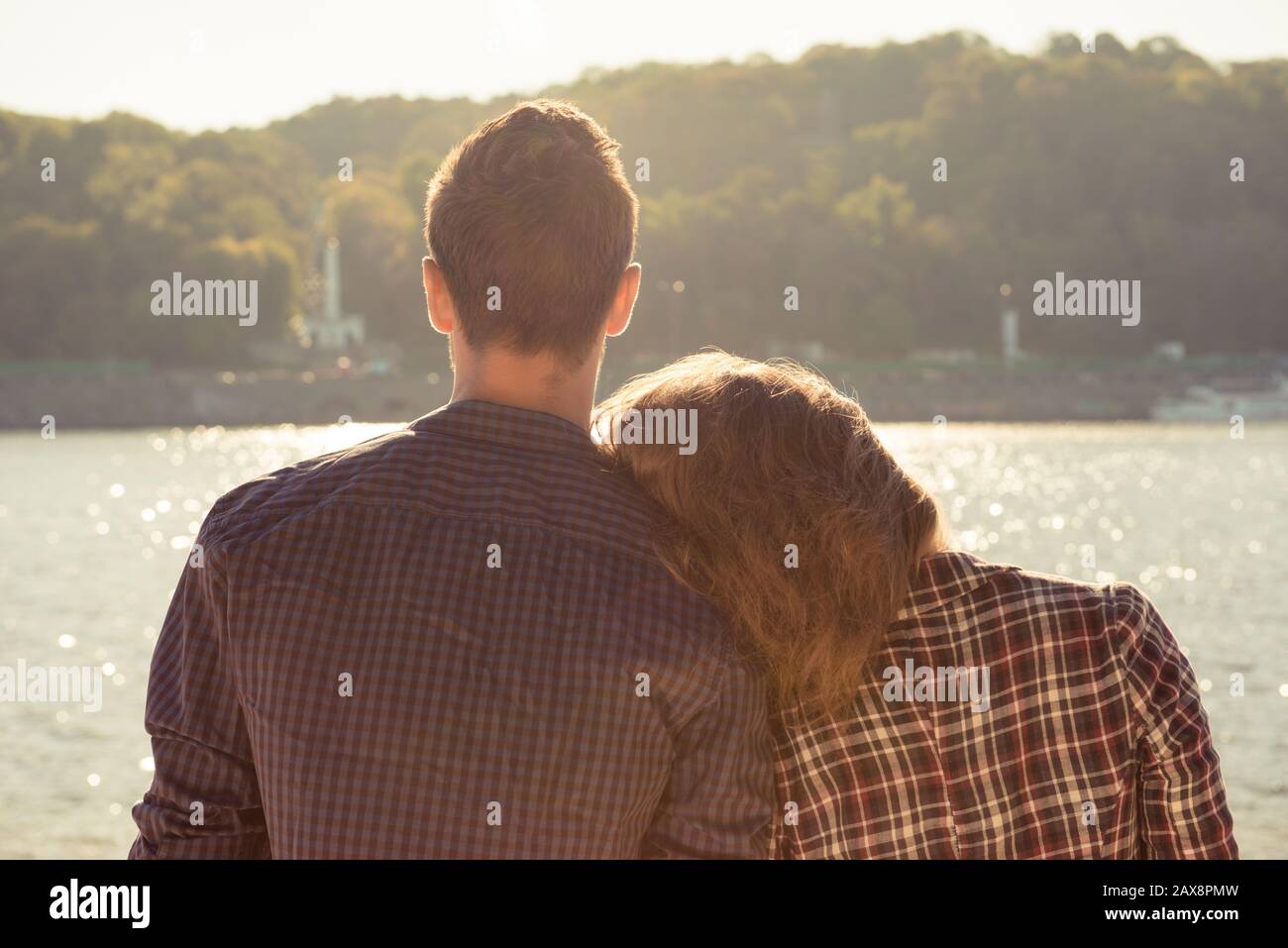 Back view of romantic couple in love watching at the river Stock Photo ...