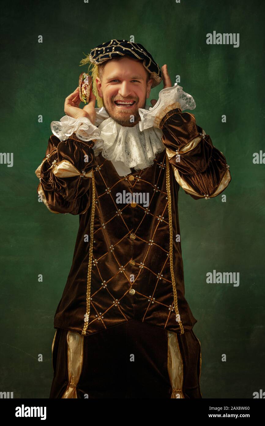 Trying new. Portrait of medieval young man in vintage clothing with ...