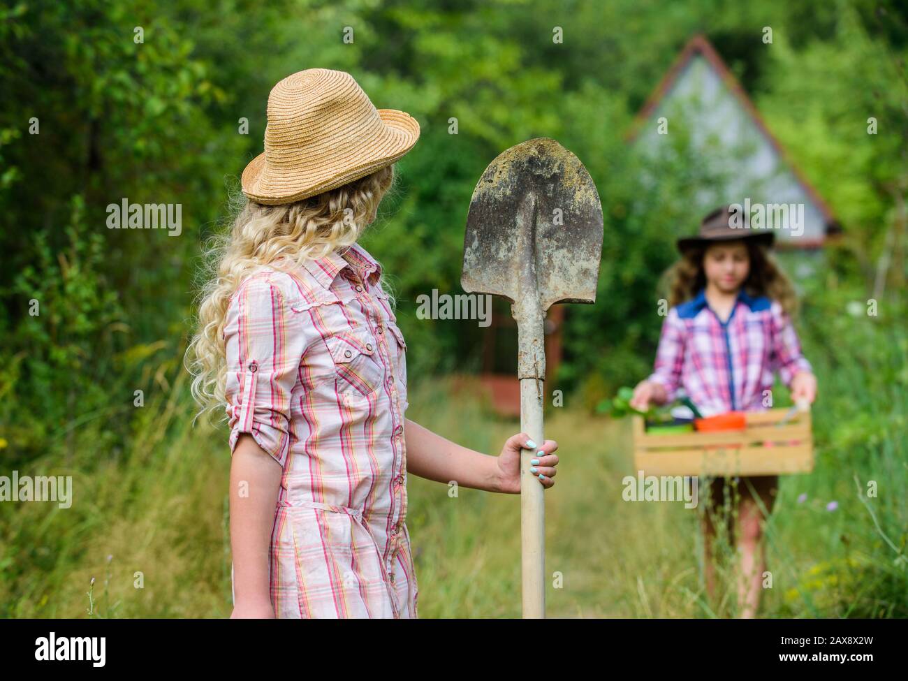 Girls with gardening tools. Summer at countryside. Sisters helping at ...