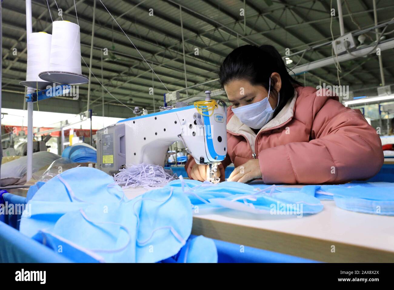 Chinese workers manufacture face masks at a factory during the outbreak ...