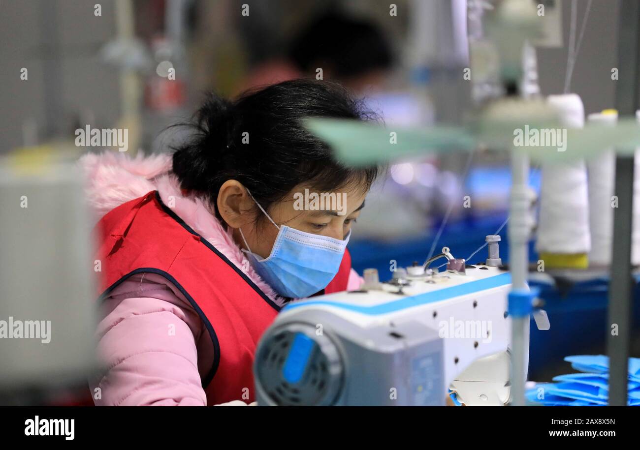 Chinese workers manufacture face masks at a factory during the outbreak ...