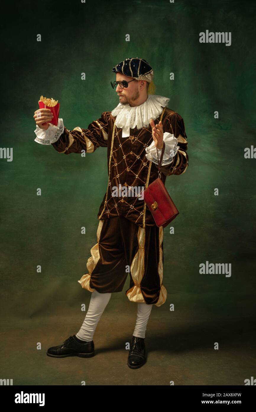 Delicious fried potato. Portrait of medieval young man in vintage ...