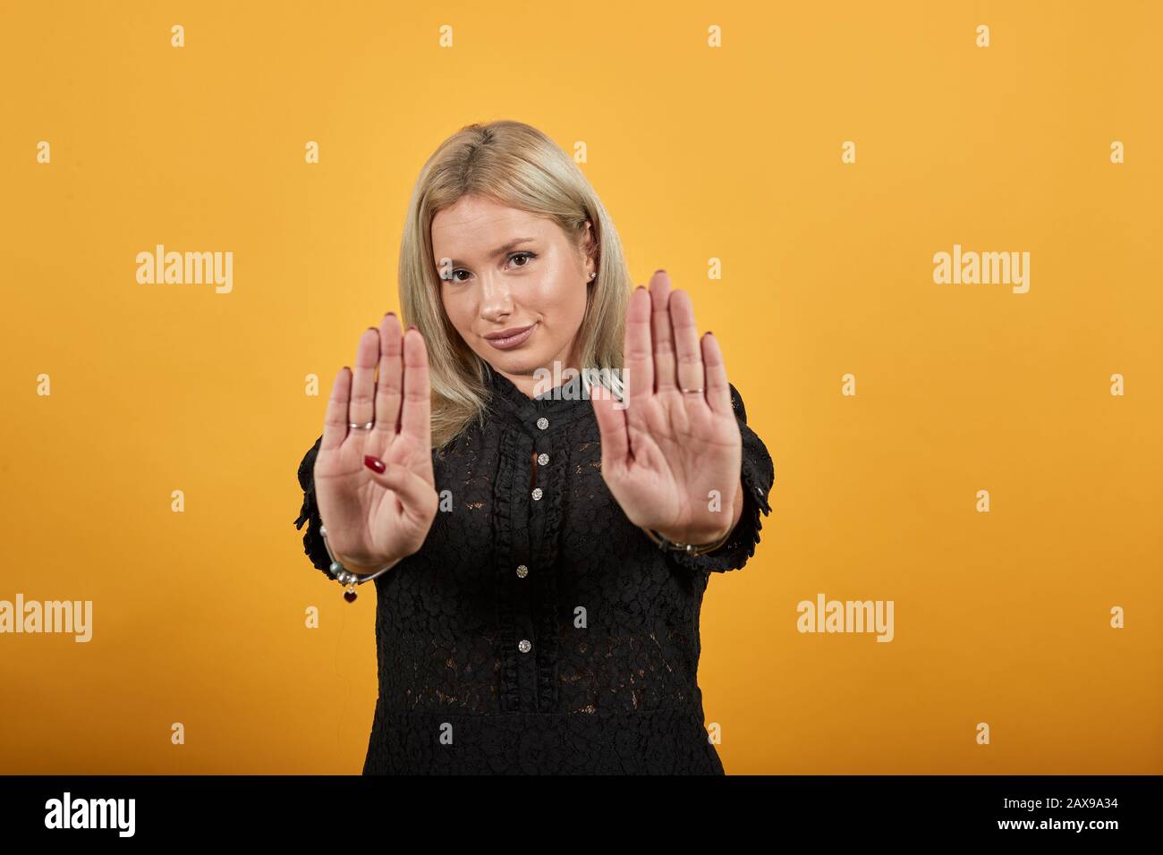 girl in black dress smiling woman shows her palms what the stop sign ...