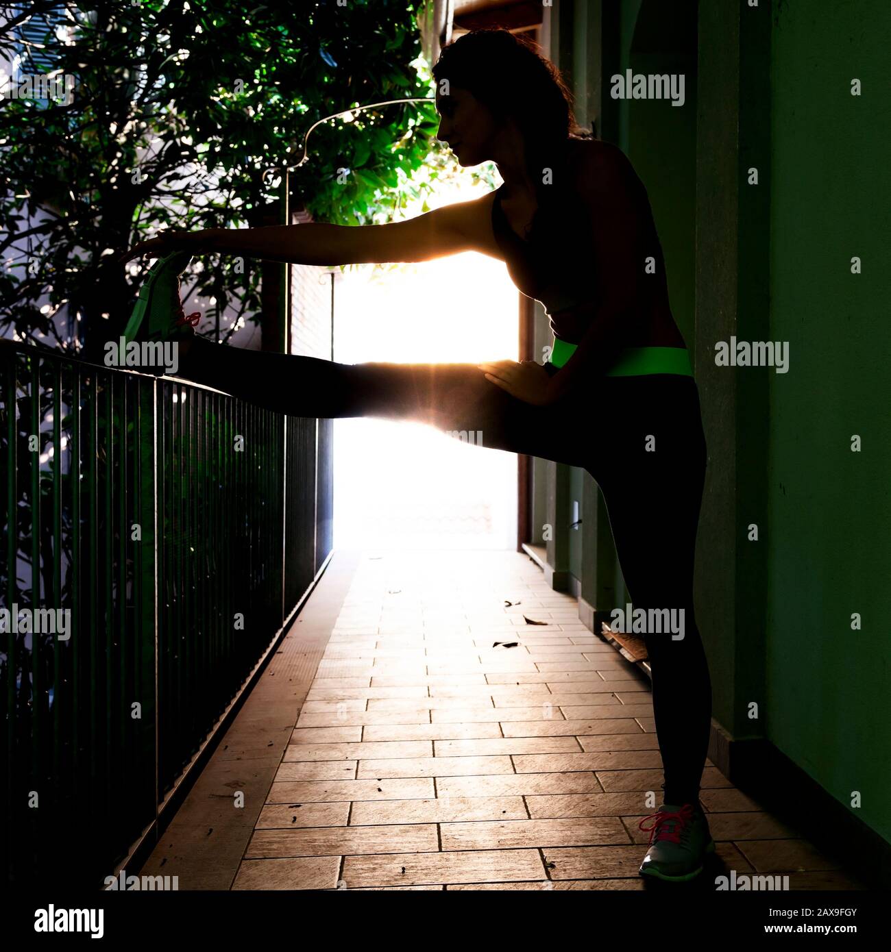 pretty female athlete does stretching after gymnastic exercises in ...