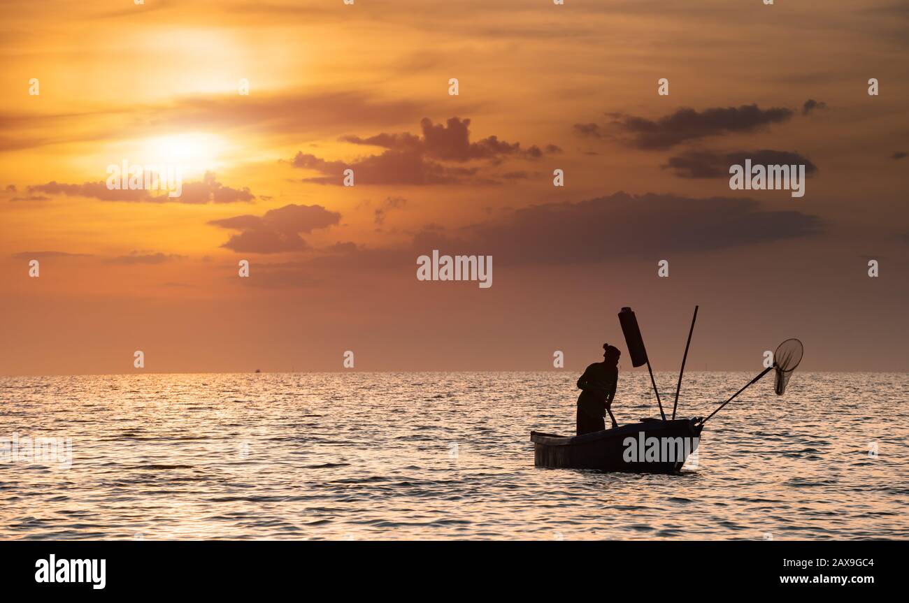 Silhouette of fisherman with warm and sunset low lighting dark shadow ...