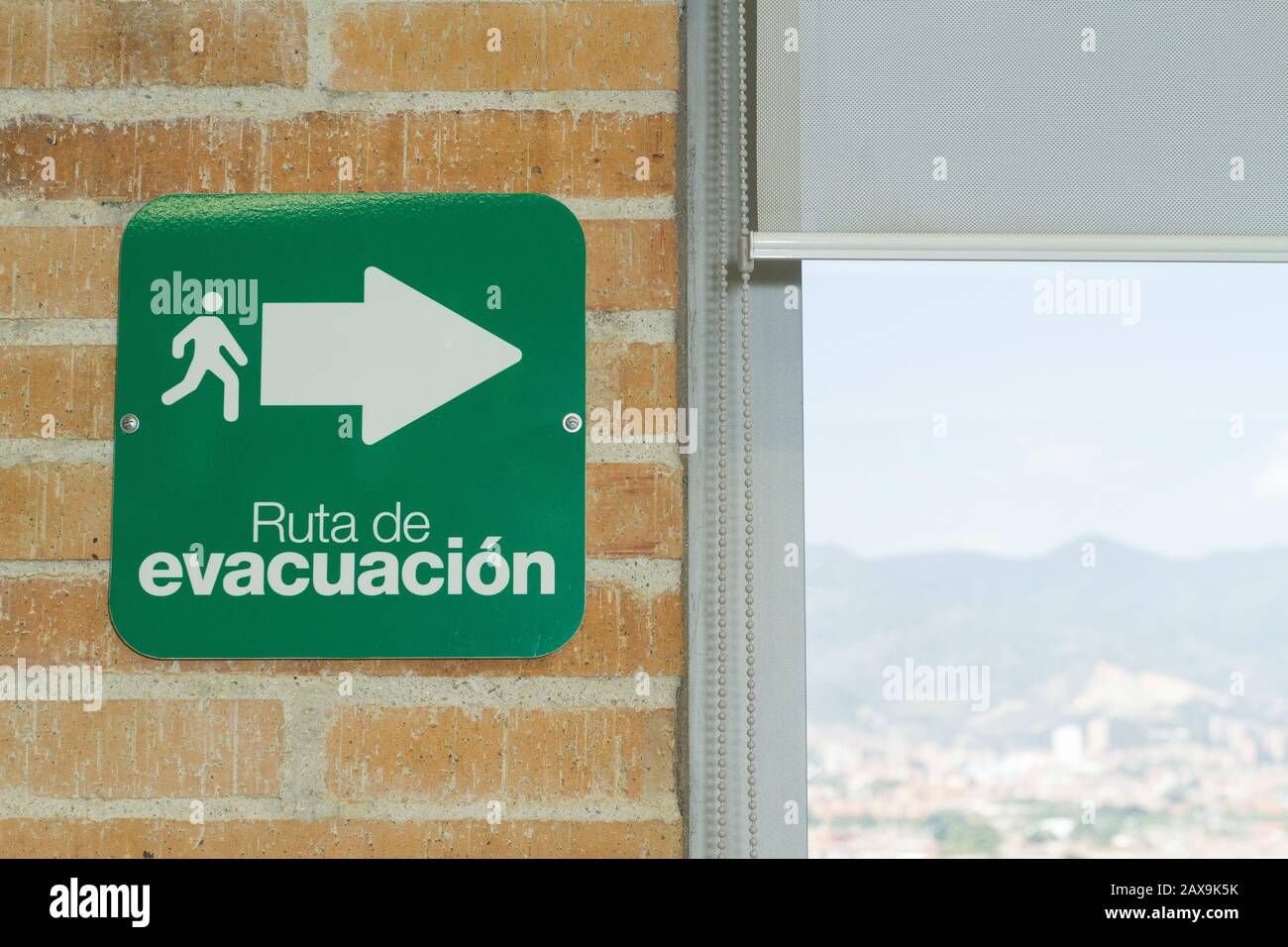evacuation route sign, text in spanish Stock Photo - Alamy