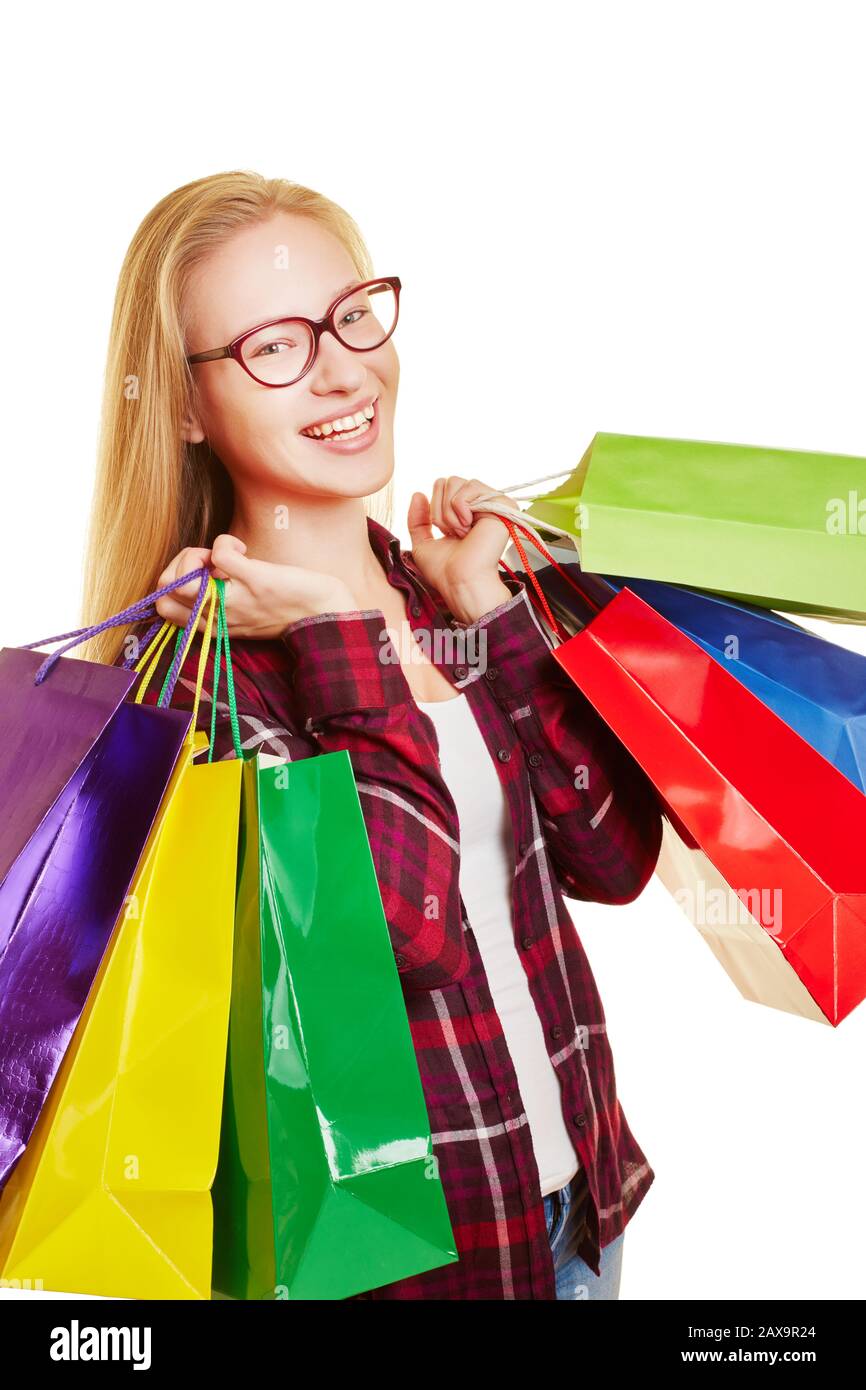 Young woman smiles with lots of colorful shopping bags in her hands ...