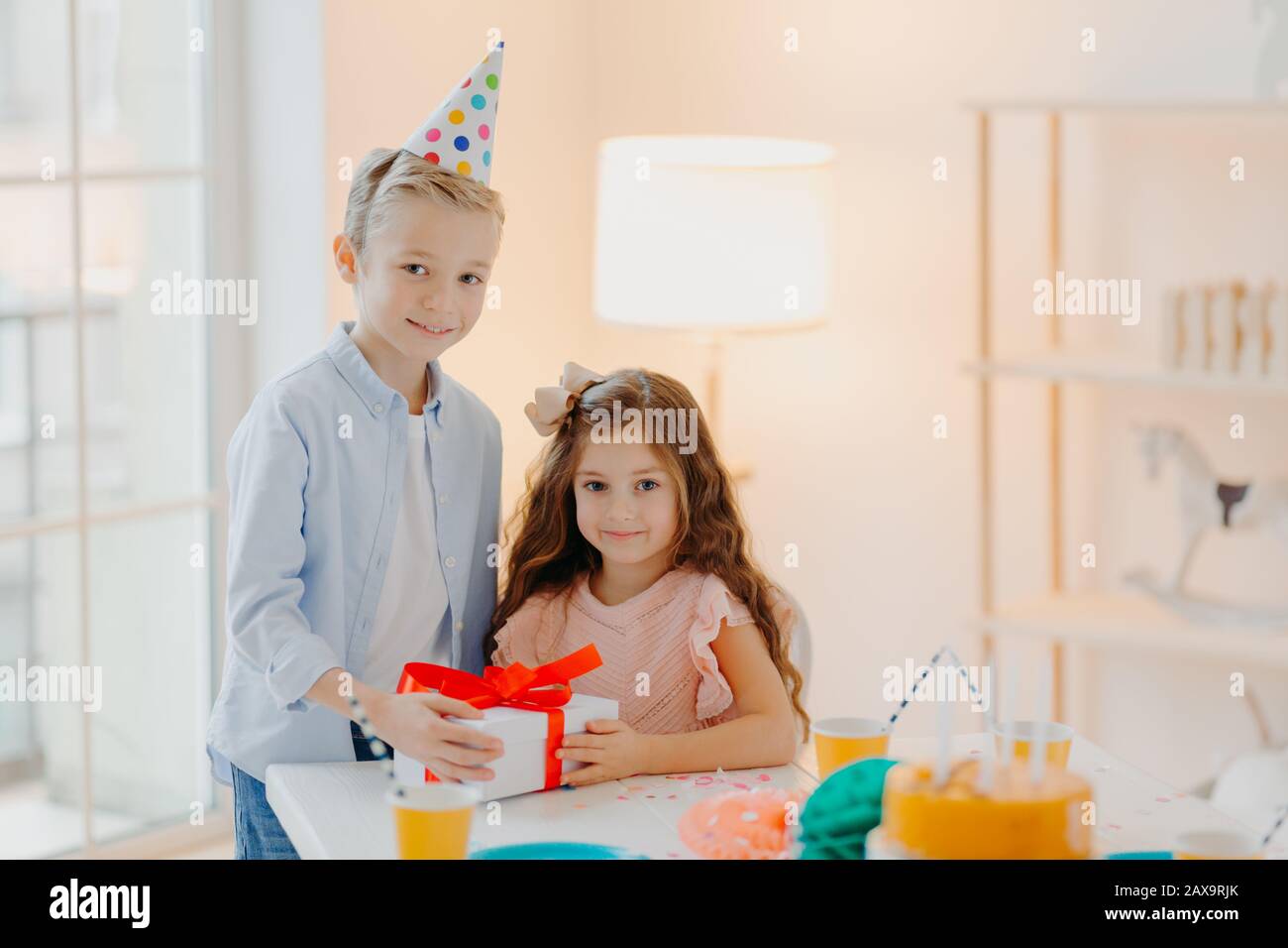Handsome small boy gives present box to girl, celebrate birthday ...