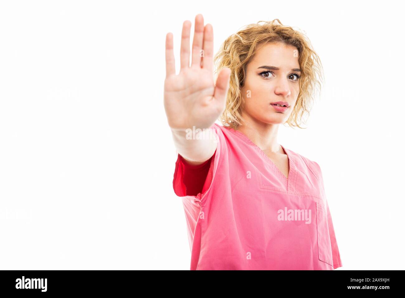 Portrait of nurse wearing pink scrub showing stop gesture isolated on ...