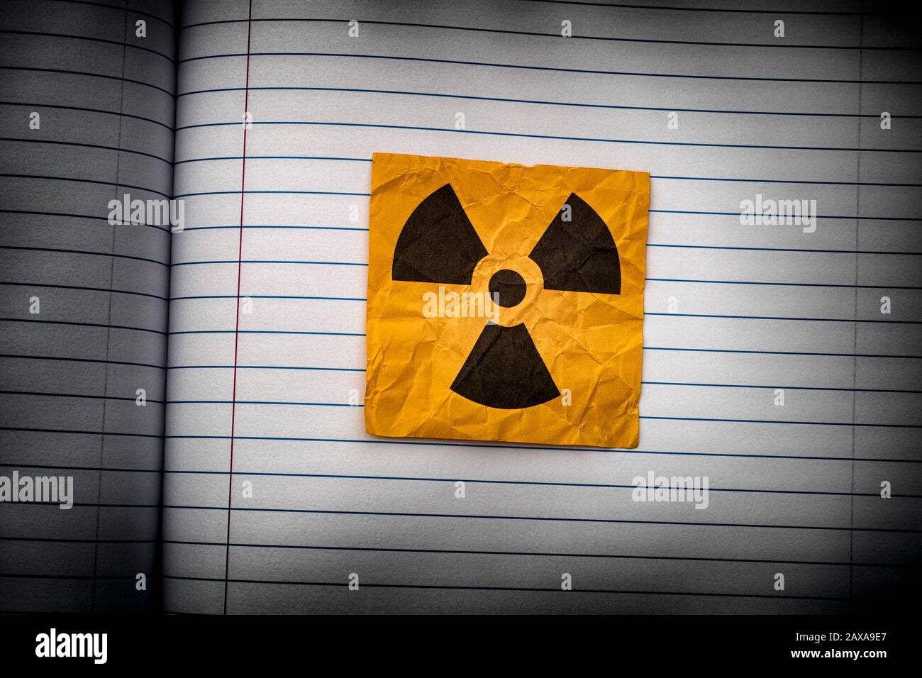 Radiation warning sign on a lined paper. Close up Stock Photo - Alamy