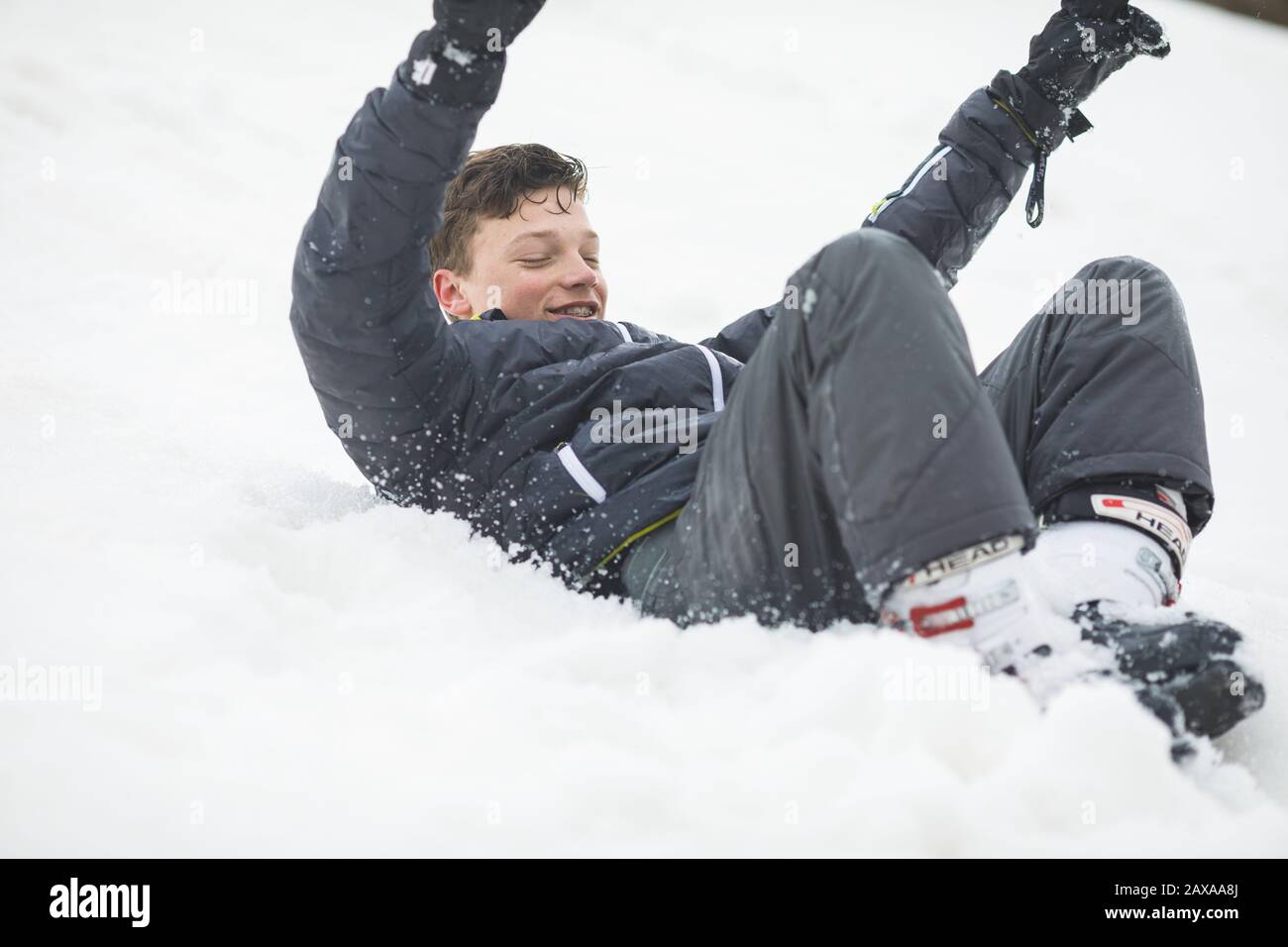 Teenager boy playing in the snow and having fun in the cold weather ...