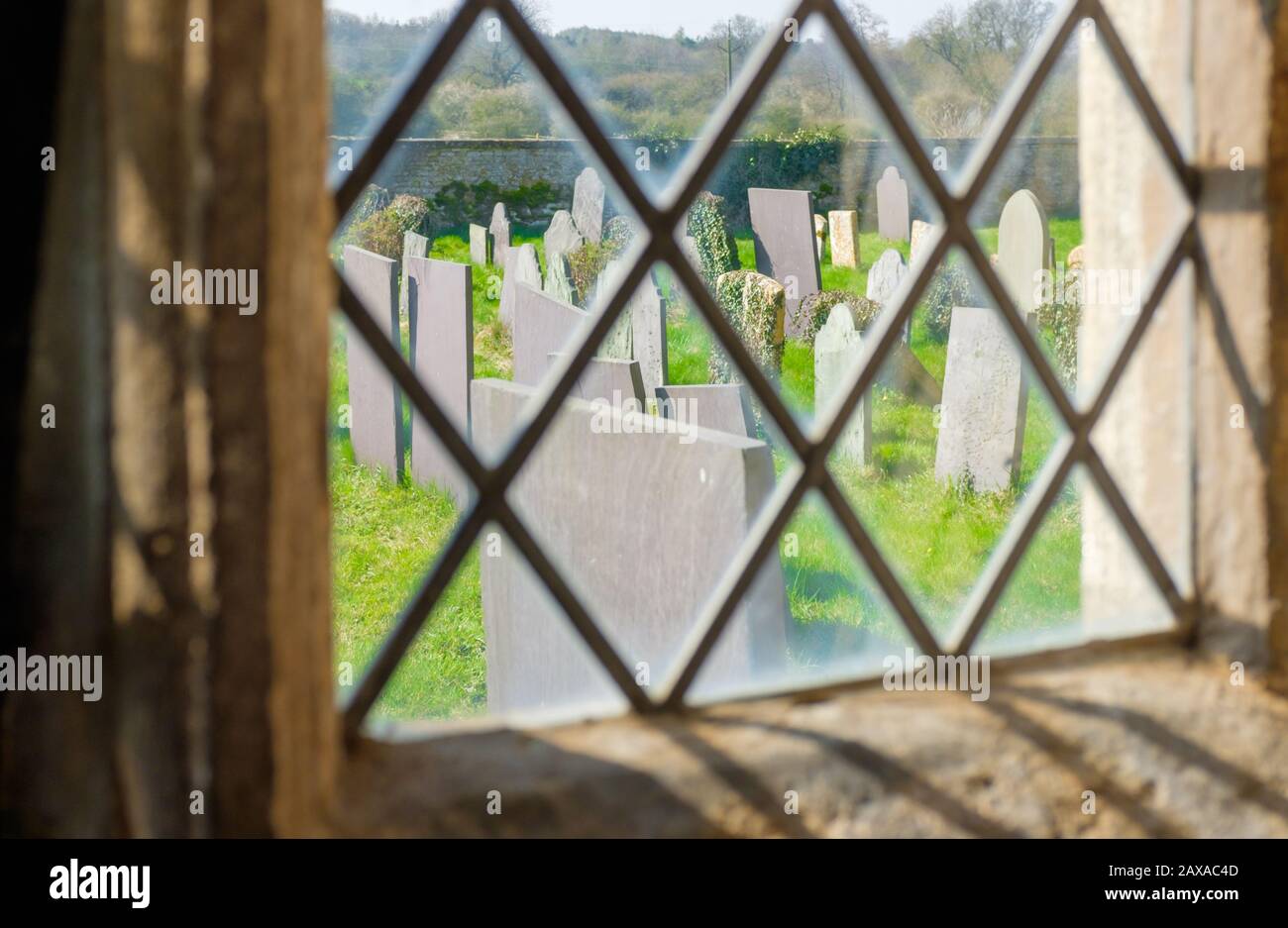 View through a church window onto the church graveyard, England, U.K ...