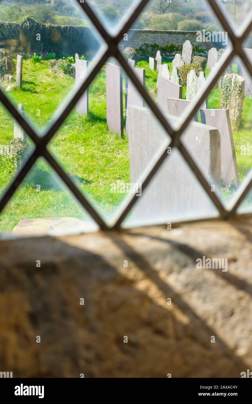 View through a church window onto the church graveyard, England, U.K ...
