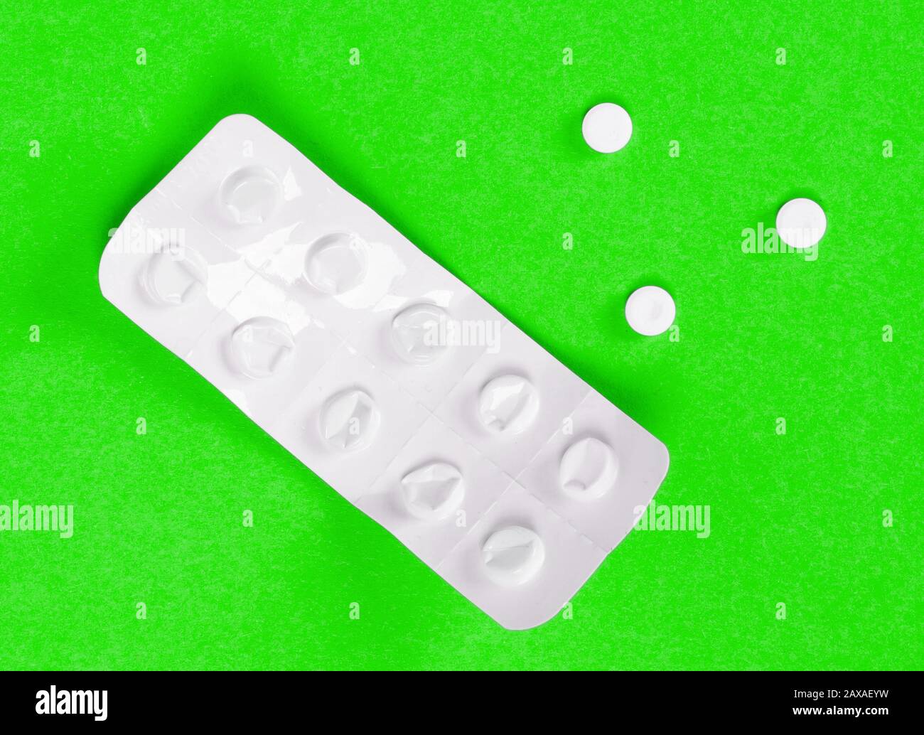 Pill strip isolated on a green background Stock Photo - Alamy