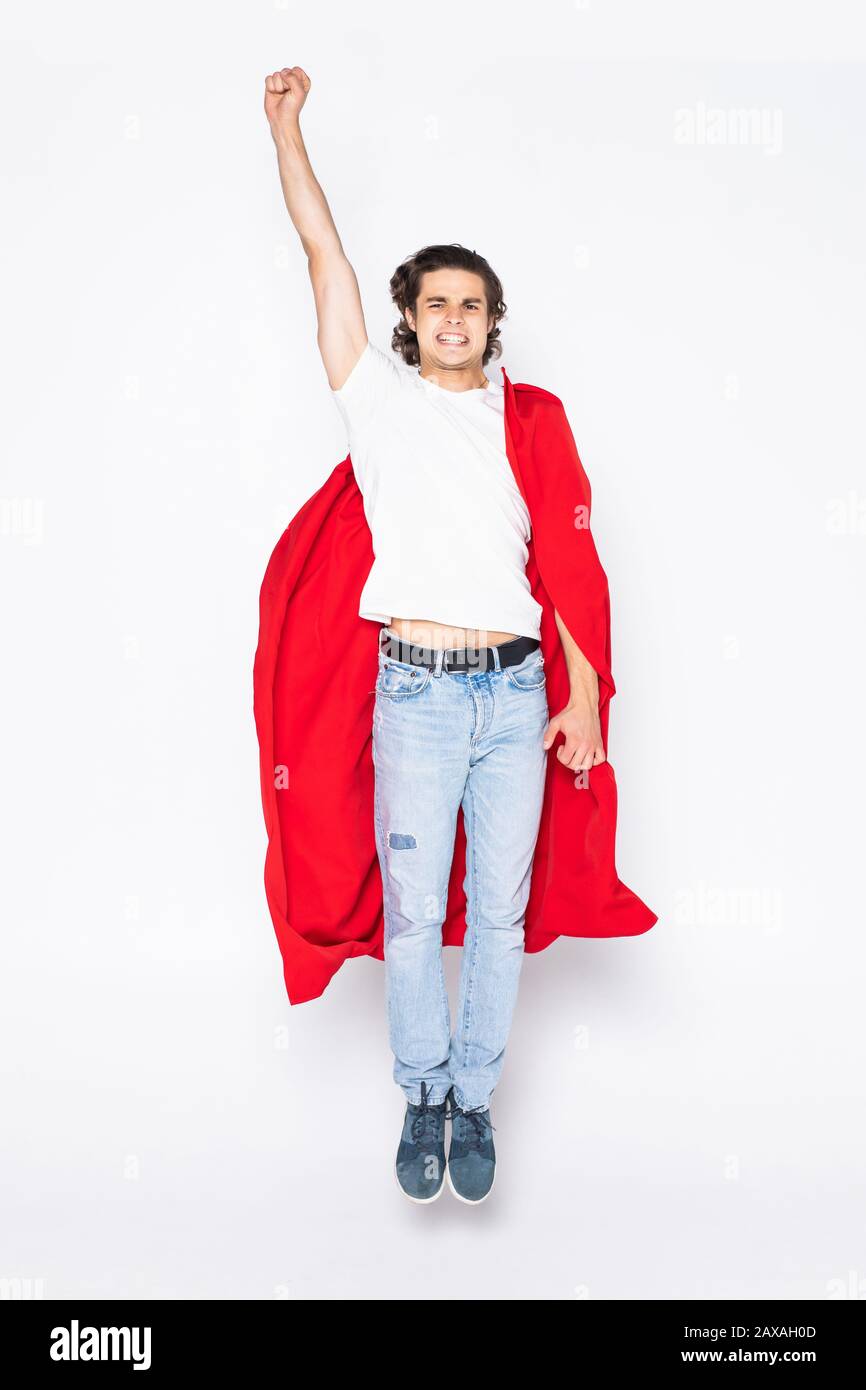 Portrait of man wearing bright super look outfit mantle isolated over ...
