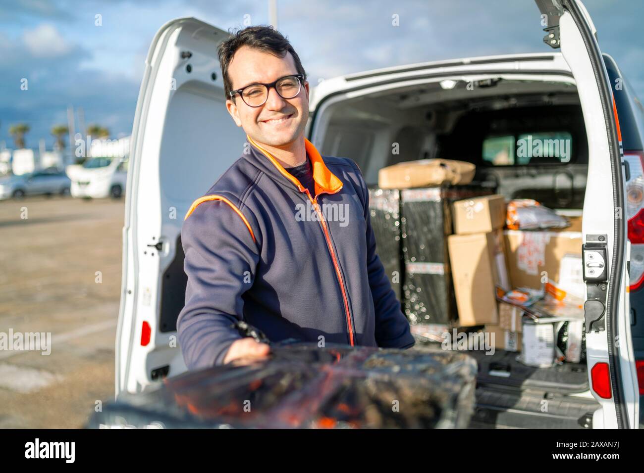 Delivery man handing out a parcel to the camera Stock Photo - Alamy