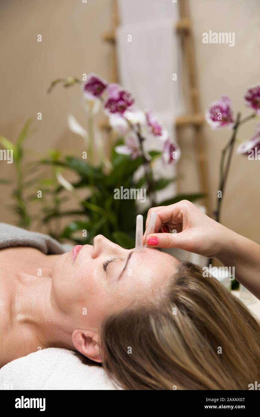 Closeup of cup applied to facial skin of a female patient as part of ...