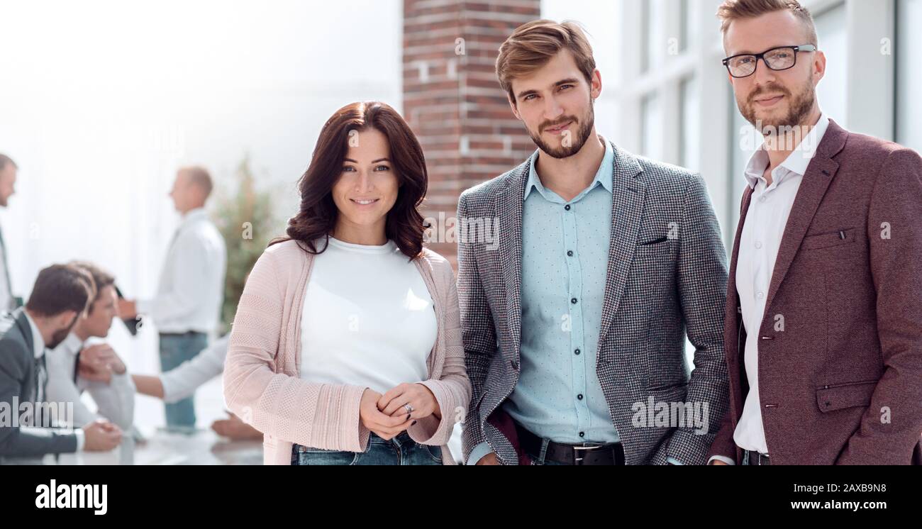three young employees standing in a modern office Stock Photo - Alamy