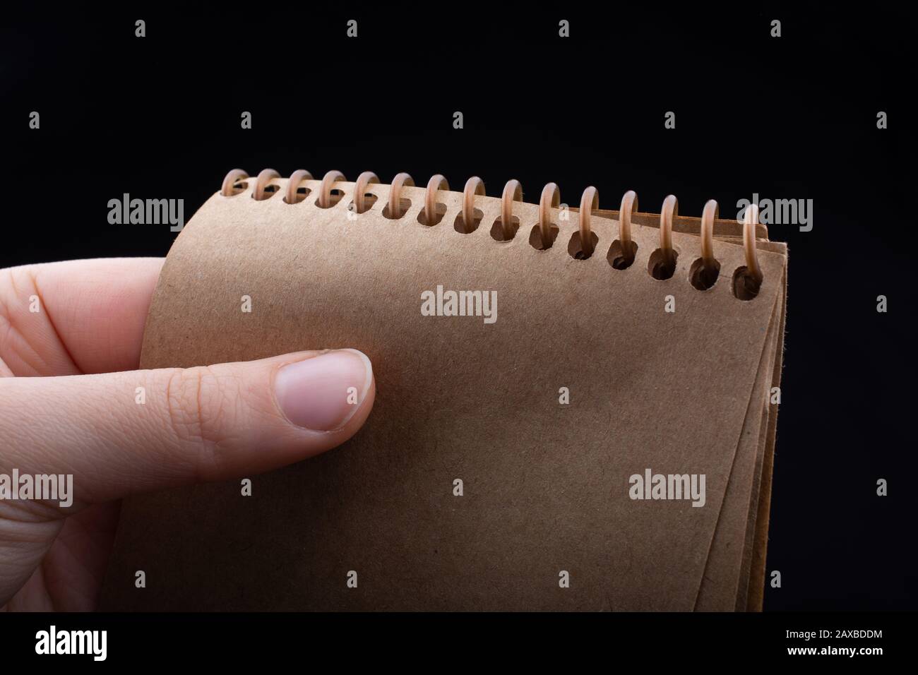 White notebook in hand on a black color background Stock Photo - Alamy