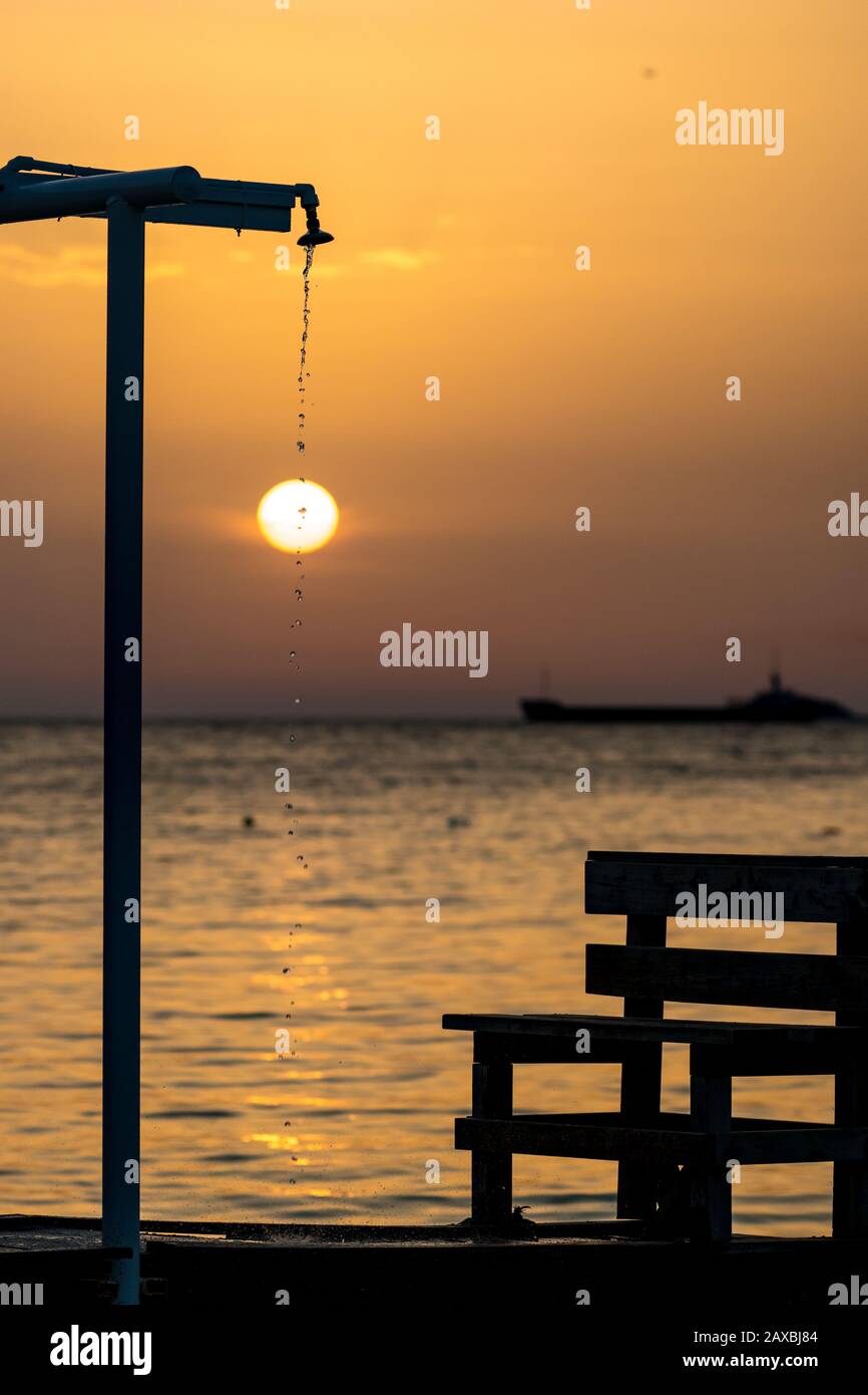 Focus on shower with dripping water droplets and bench silhouettes at ...