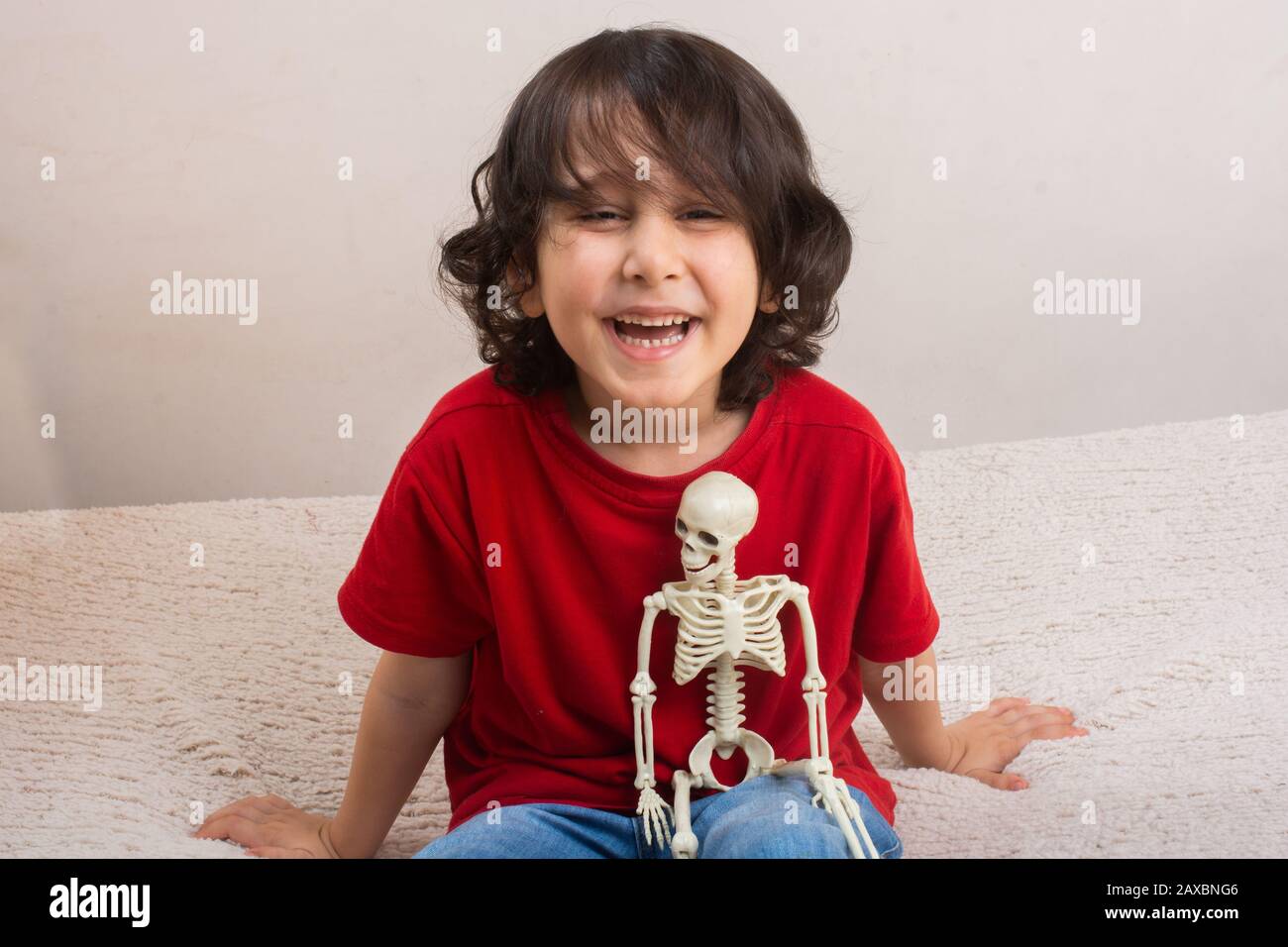 Little boy holding a small size artificial skeleton in hand Stock Photo ...
