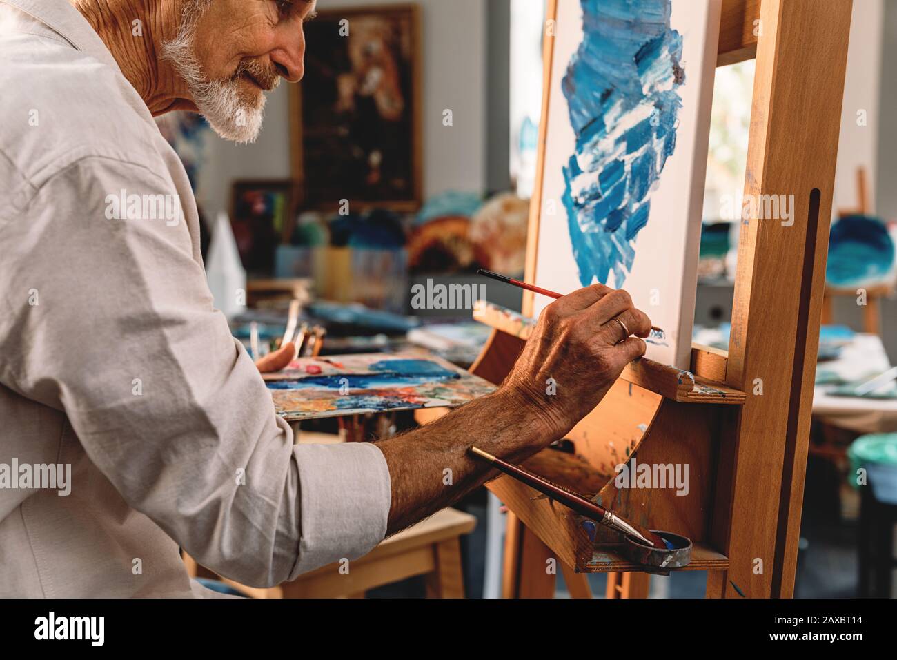 Close up of a senior artist drawing on canvas in studio Stock Photo - Alamy