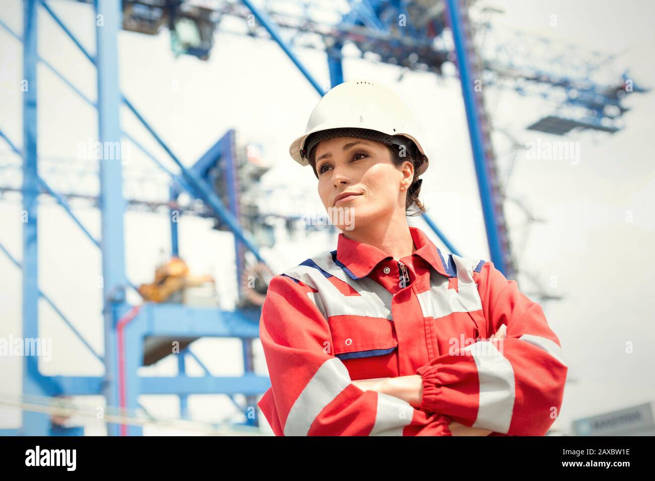 Confident female dock worker with arms crossed at shipyard Stock Photo ...