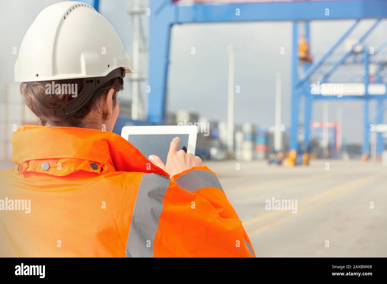 Female dock worker using digital tablet at shipyard Stock Photo - Alamy