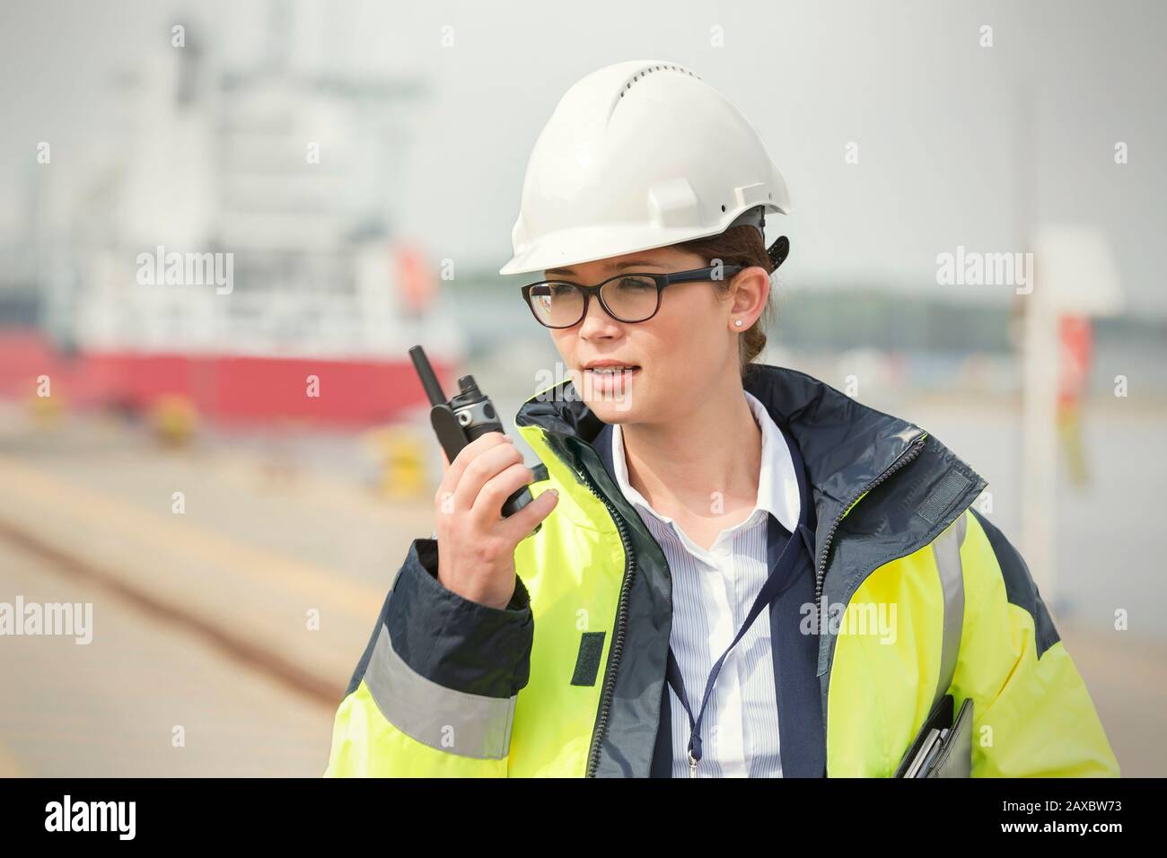 Female dock worker with walkie-talkie at shipyard Stock Photo - Alamy