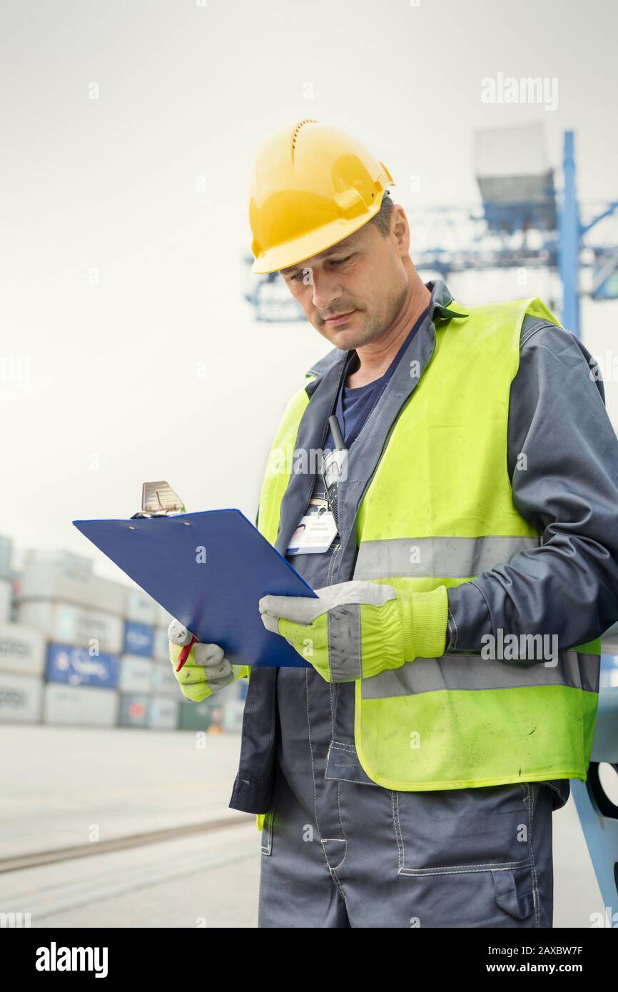 Dock worker with clipboard at shipyard Stock Photo - Alamy