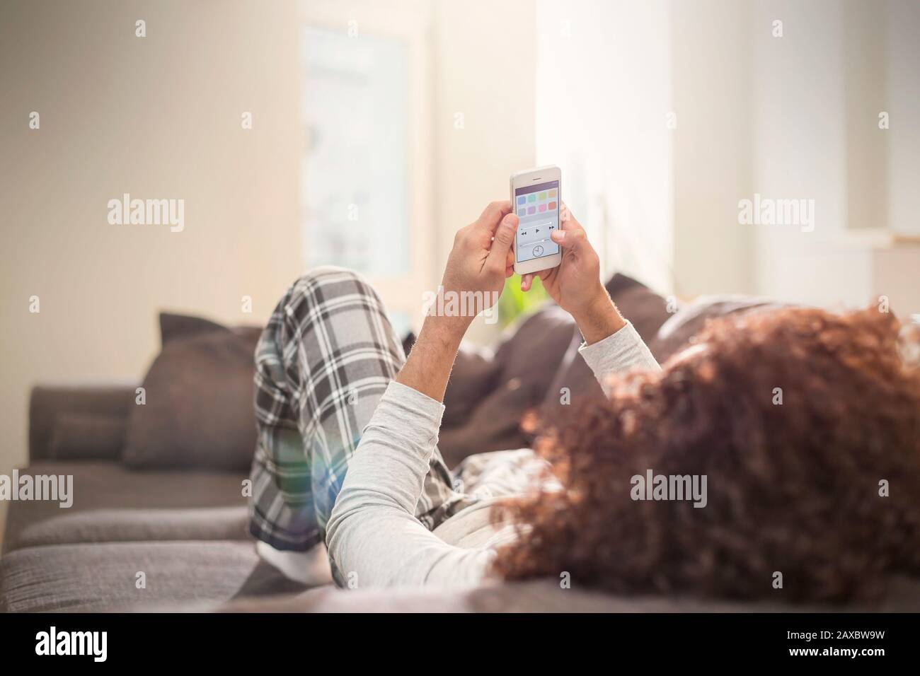 Man lying on sofa using hi-res stock photography and images - Alamy