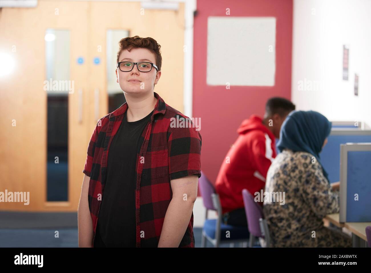 Portrait confident ambitious young male college student in library ...