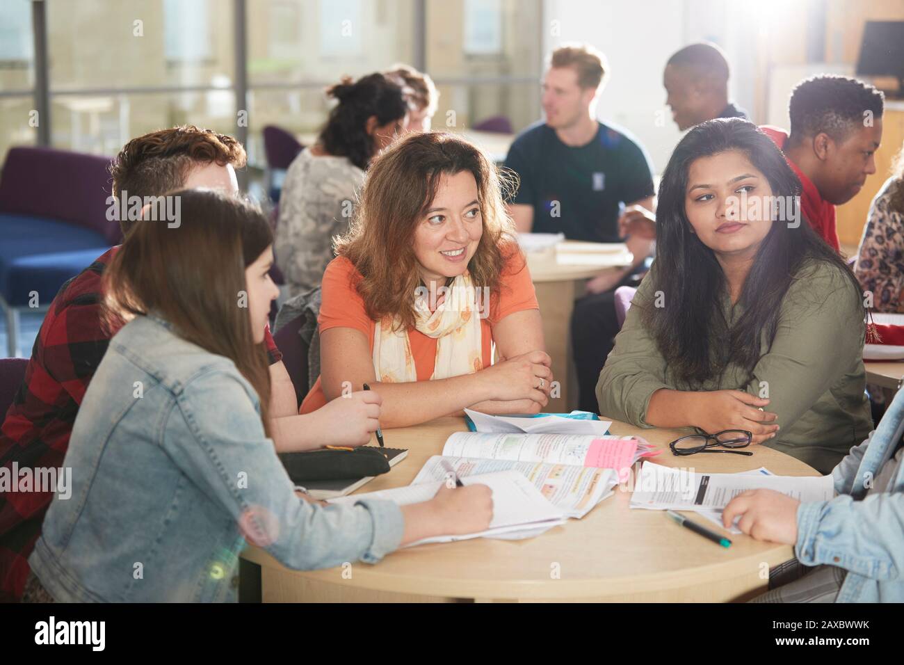 College students studying and talking at library table Stock Photo - Alamy