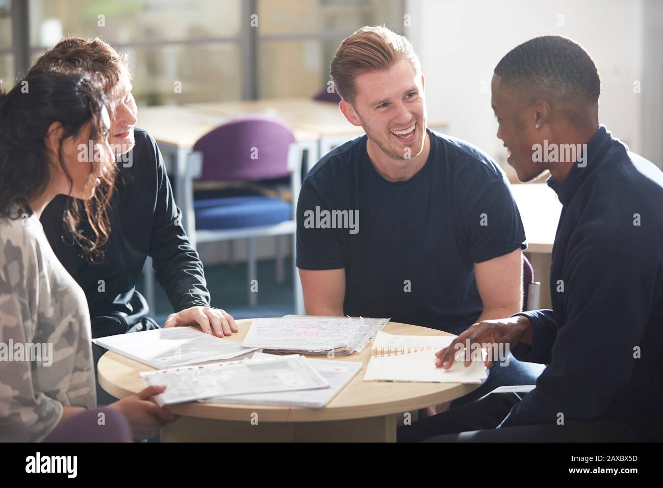 Happy young college students talking and studying in library Stock ...