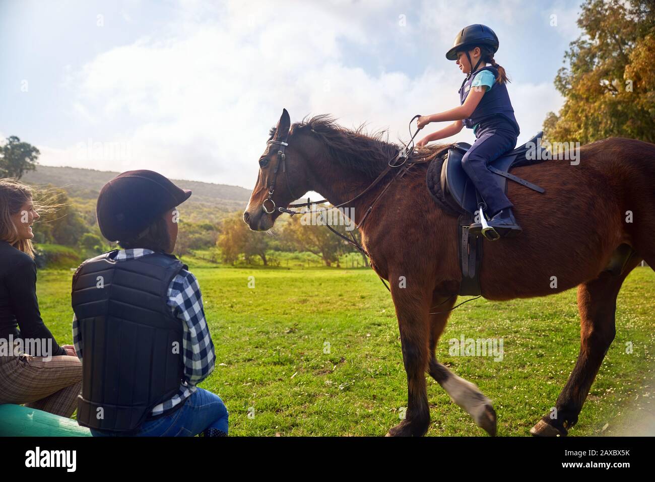 Girl learning horseback riding in rural grass paddock Stock Photo - Alamy