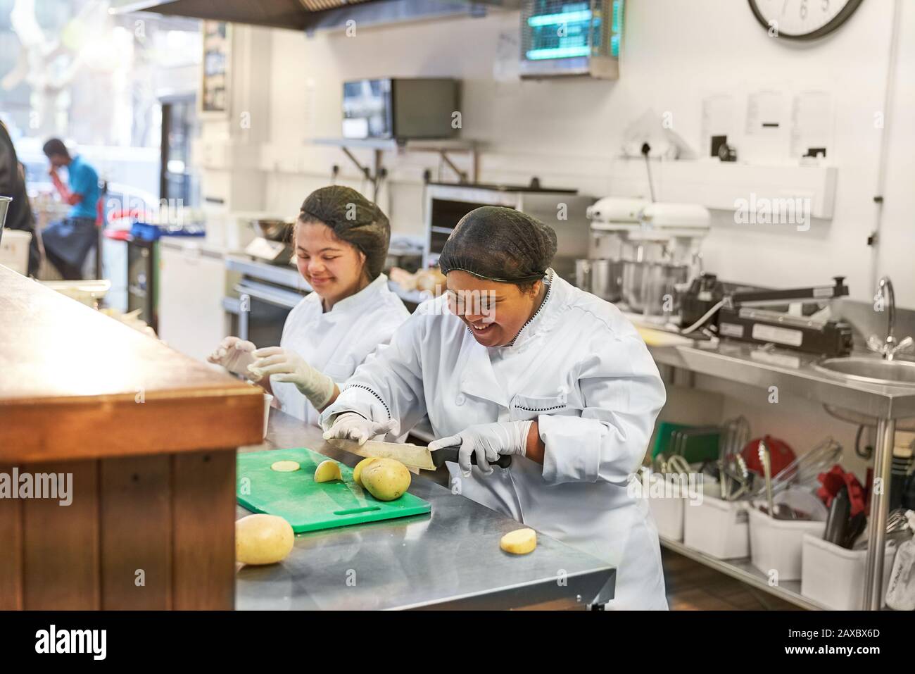 Happy young women with Down Syndrome cooking in cafe Stock Photo - Alamy