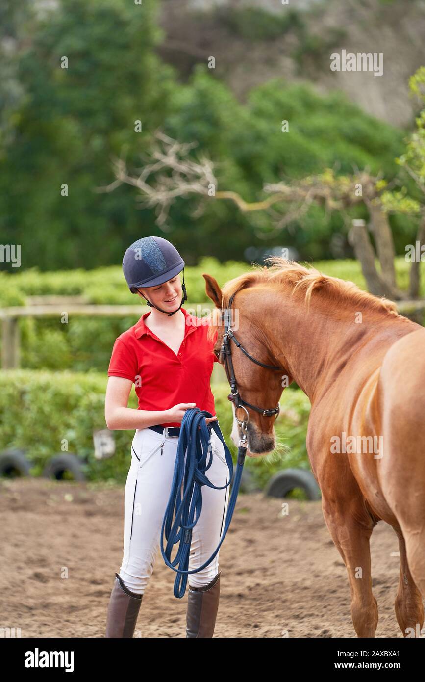 Teenage girl in equestrian helmet training horse Stock Photo - Alamy