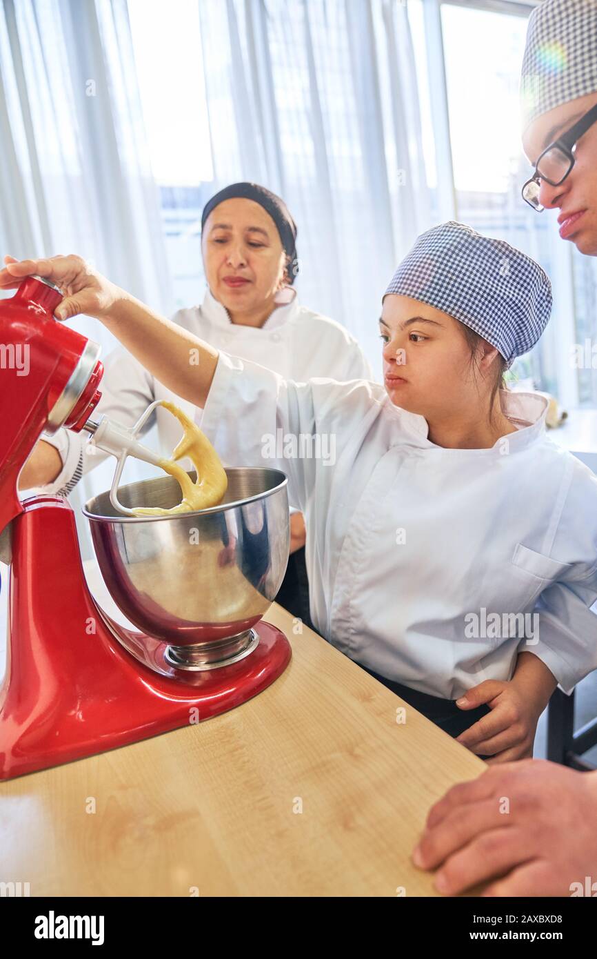 Students with Down Syndrome using stand mixer in baking class Stock ...